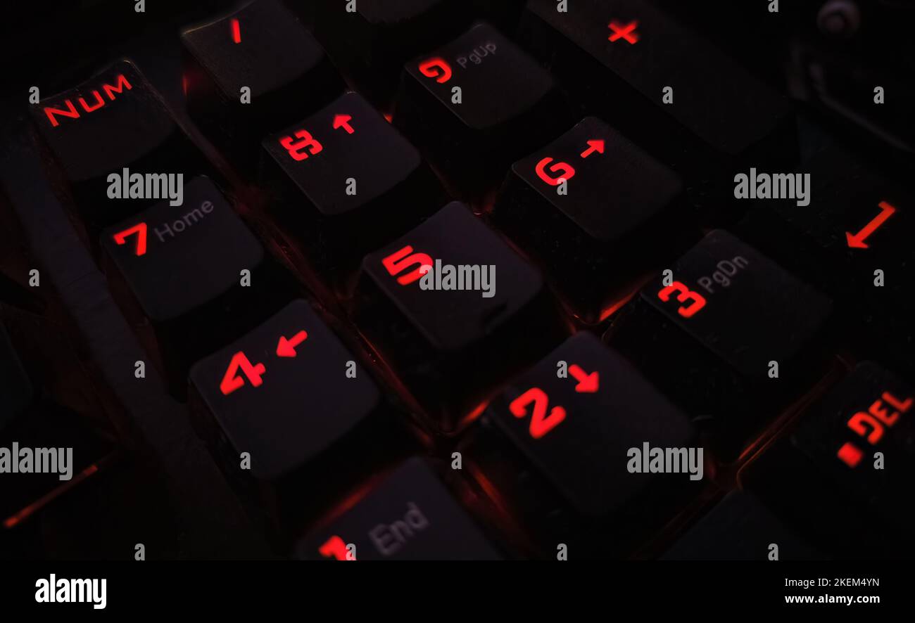 Backlit keyboard close up. Black keys with illuminated characters ...