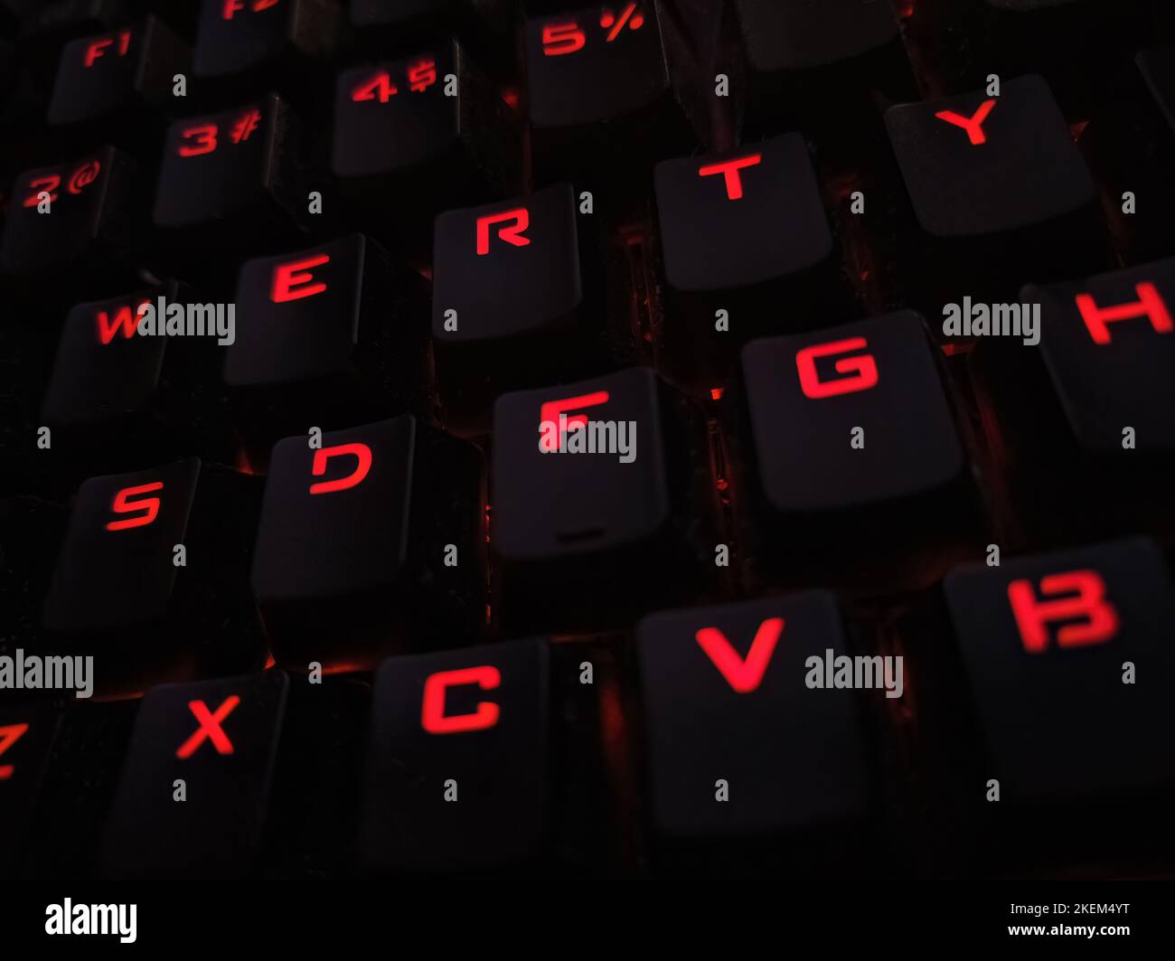 Backlit keyboard close up. Black keys with illuminated characters ...
