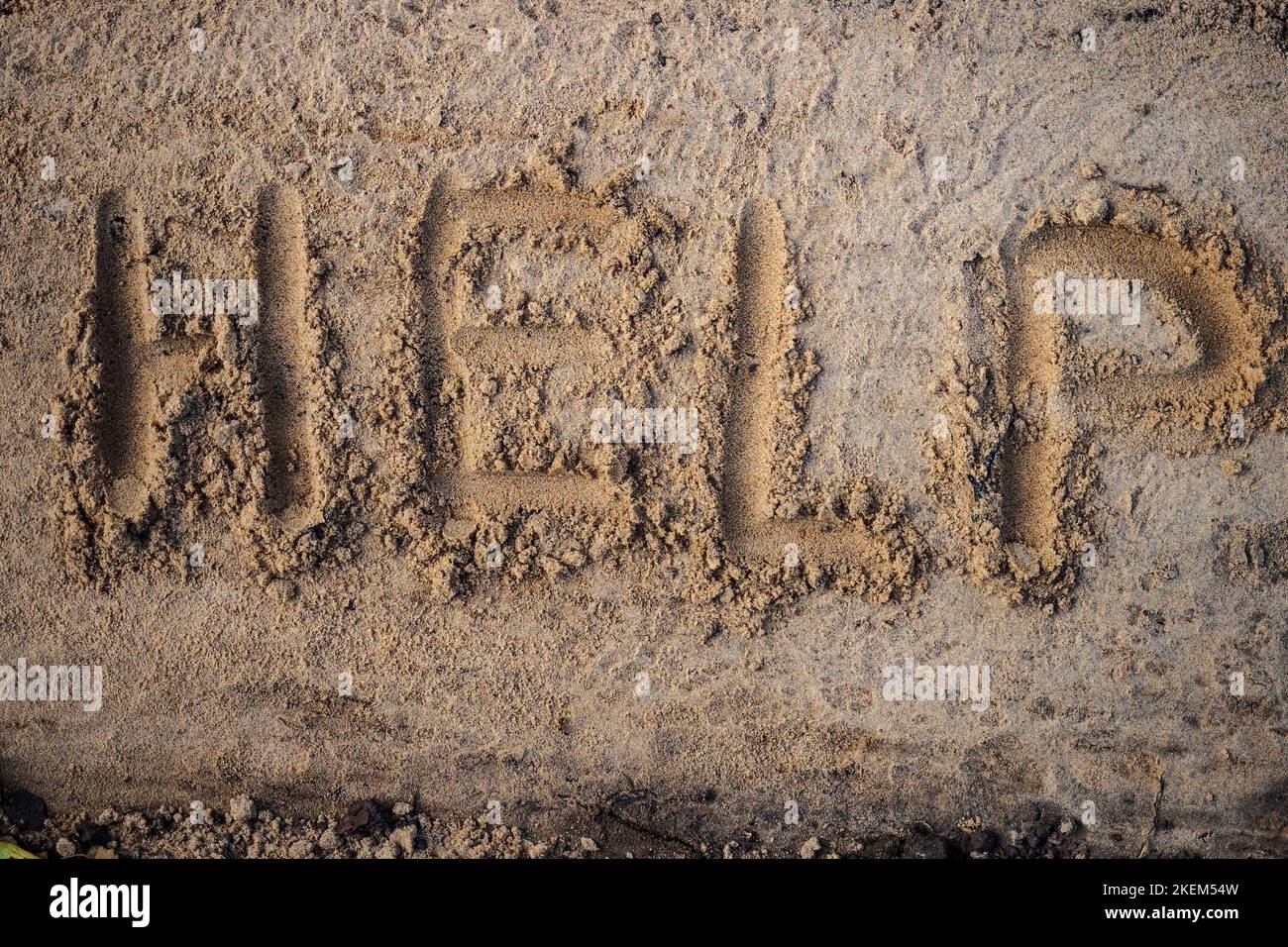 Help. Inscription in letters on sand. View from top. Appeal for ...