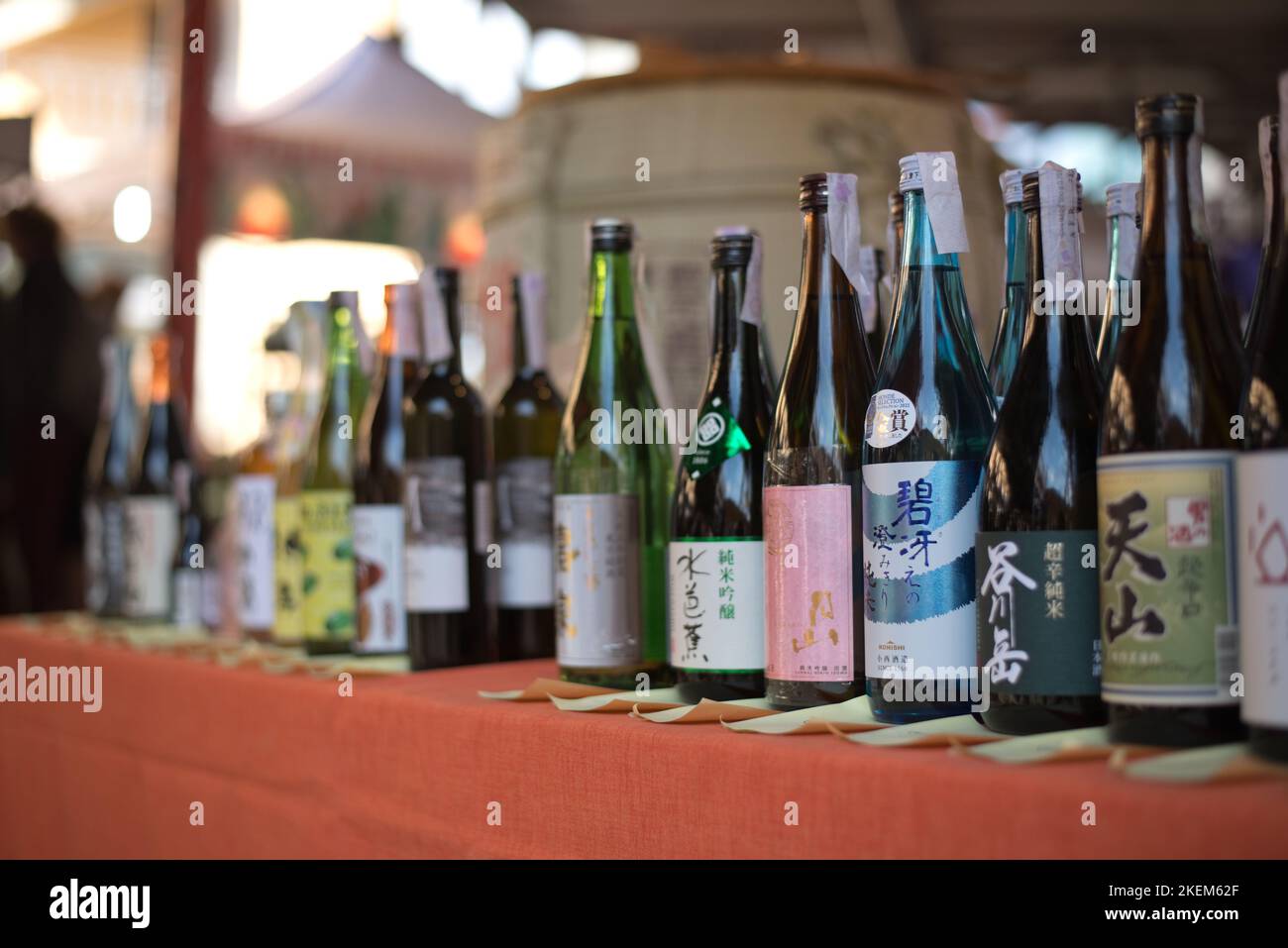Close-up of Japanese various sake bottles, for sale at a market stall ...