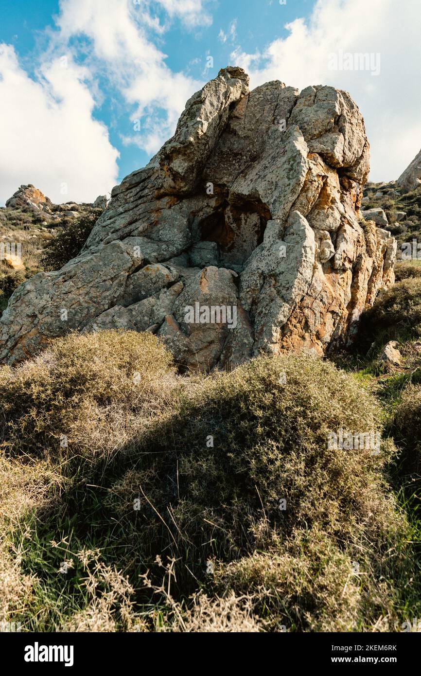 A low angle of a hill with heavy gray cliff and grass during the ...