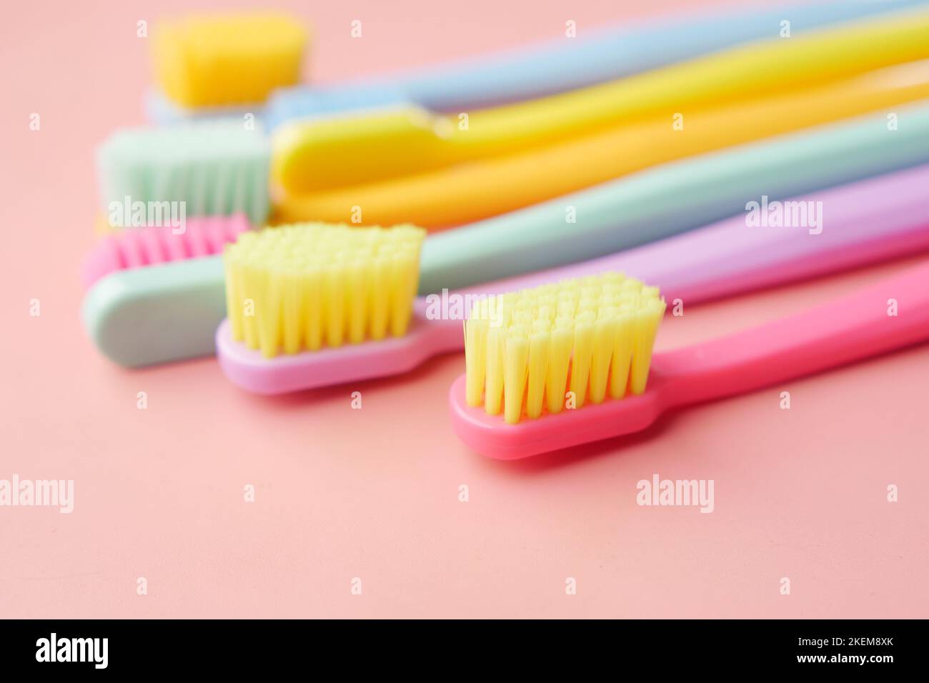colorful toothbrushes line up on pink background Stock Photo - Alamy