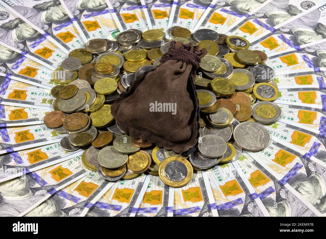 A money sack on a pile of different coins from around the world against ...