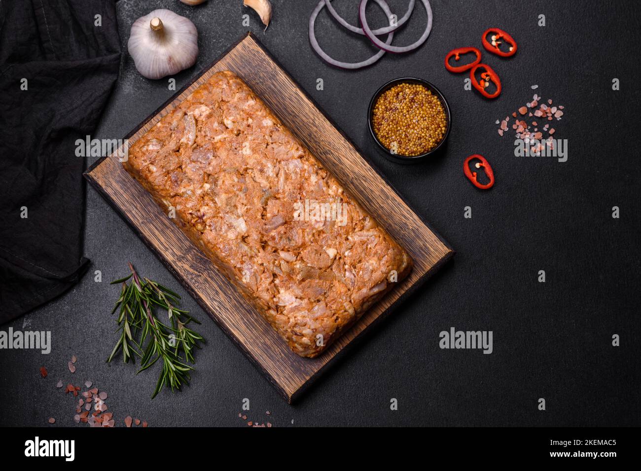 Tasty meat brawn or roll on a wooden cutting board with spices and ...