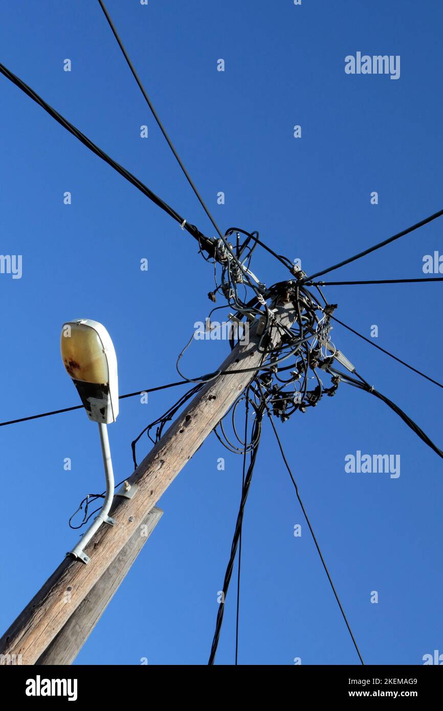 Jumble of cables and a street light on a pole. Taken at an unusual ...