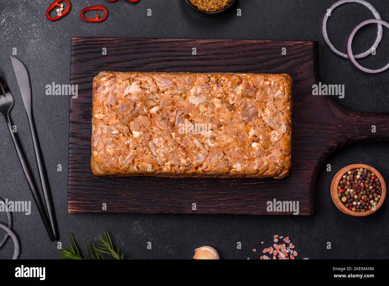 Tasty meat brawn or roll on a wooden cutting board with spices and ...