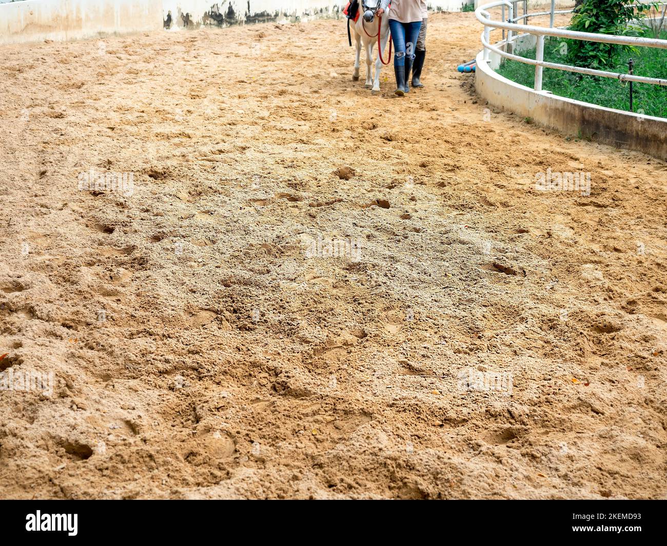 Outdoor space of sand on horse race track with horseman leading a horse ...