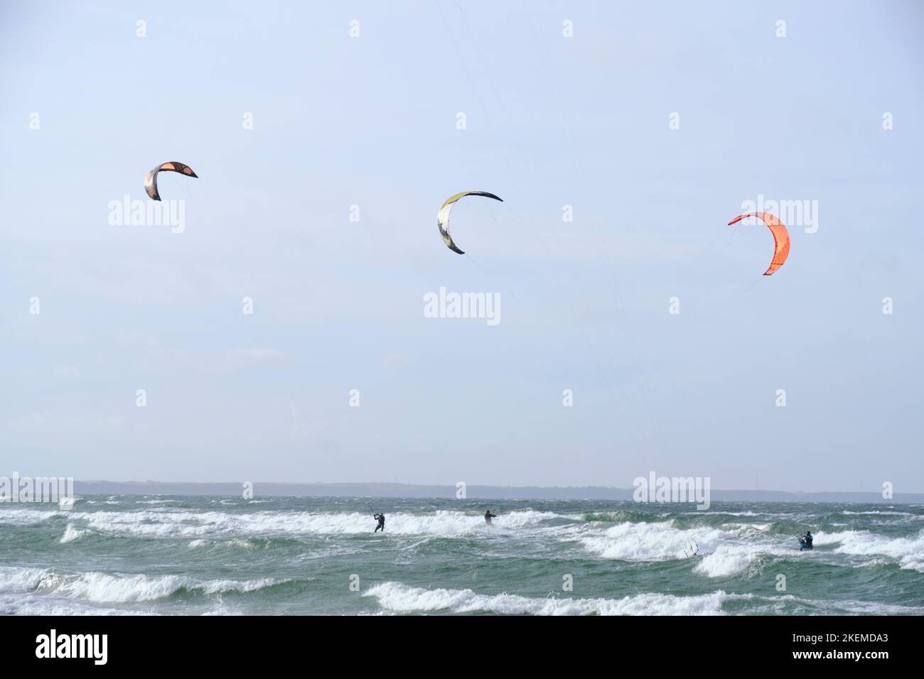 Kitesurfing, riding board waves during storm holding to flying kite ...