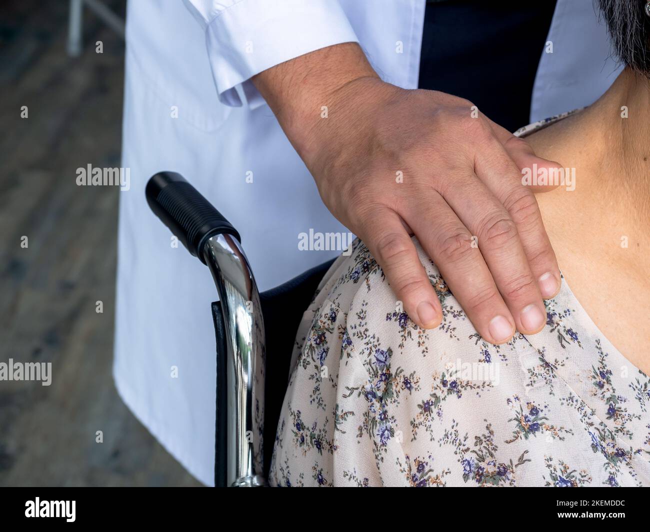 Close Up doctor's hands touching elderly patient's shoulder in a ...
