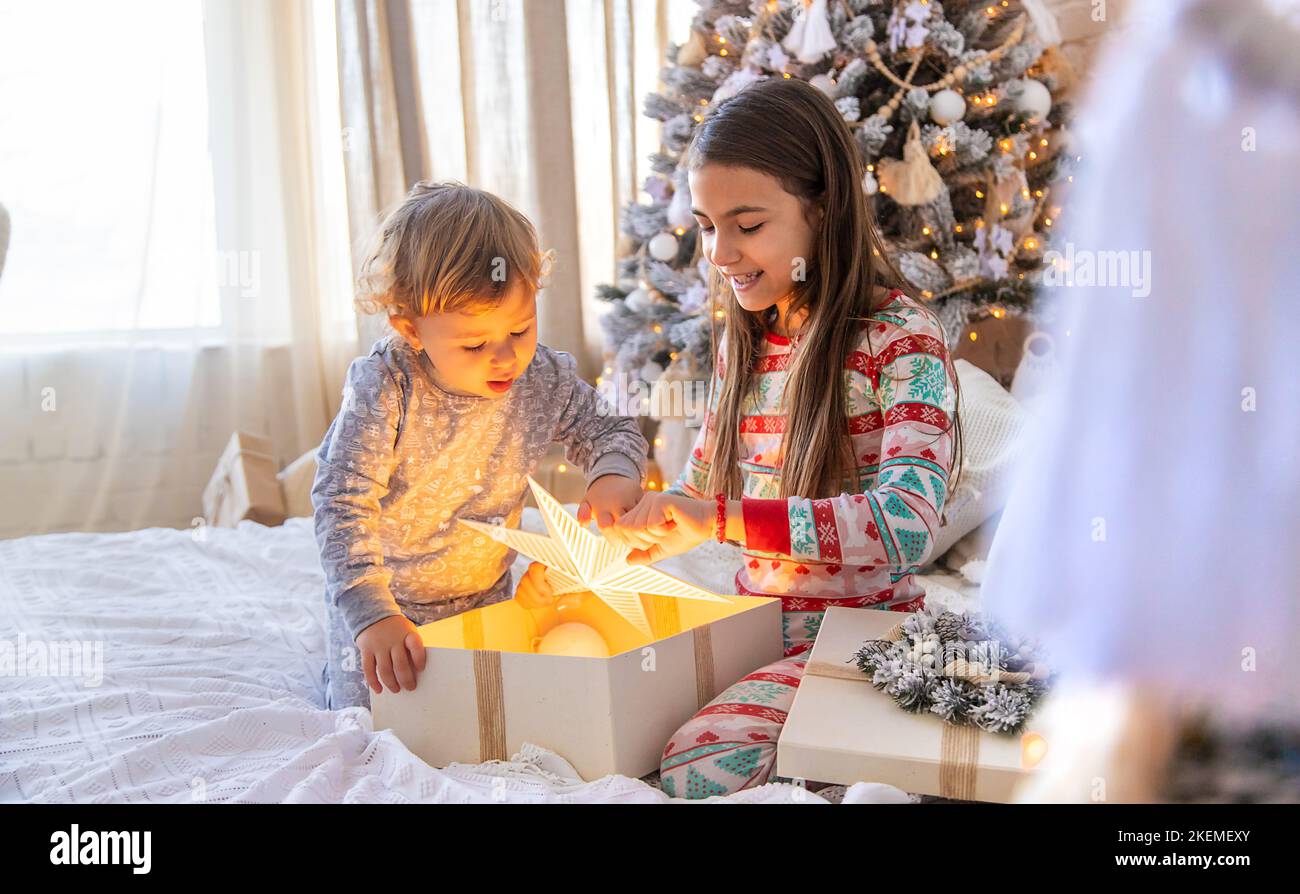 Child open Christmas gifts under the tree. Selective focus. Kid Stock ...