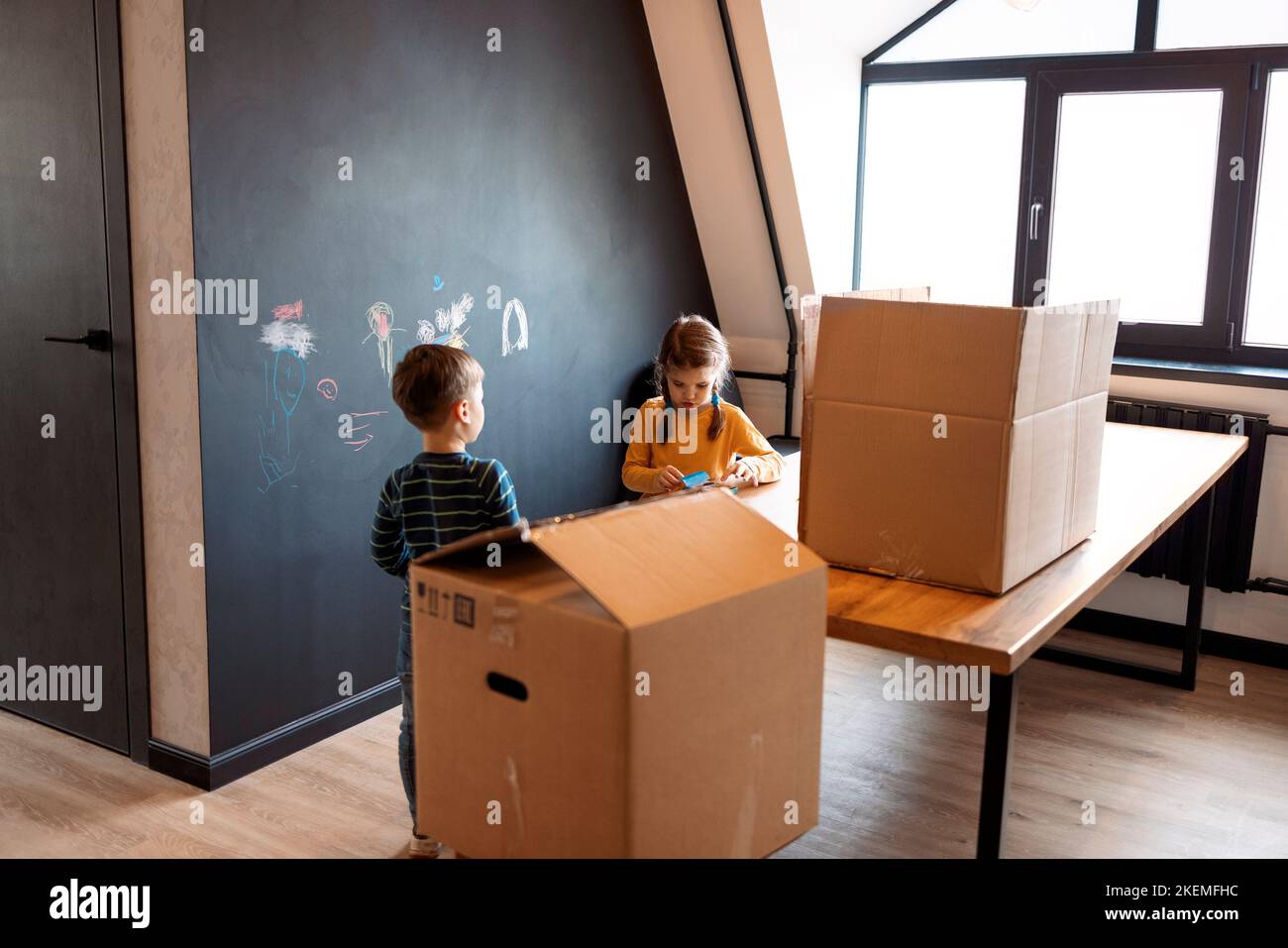 Happy family playing into new home. Child having fun together. Sister ...