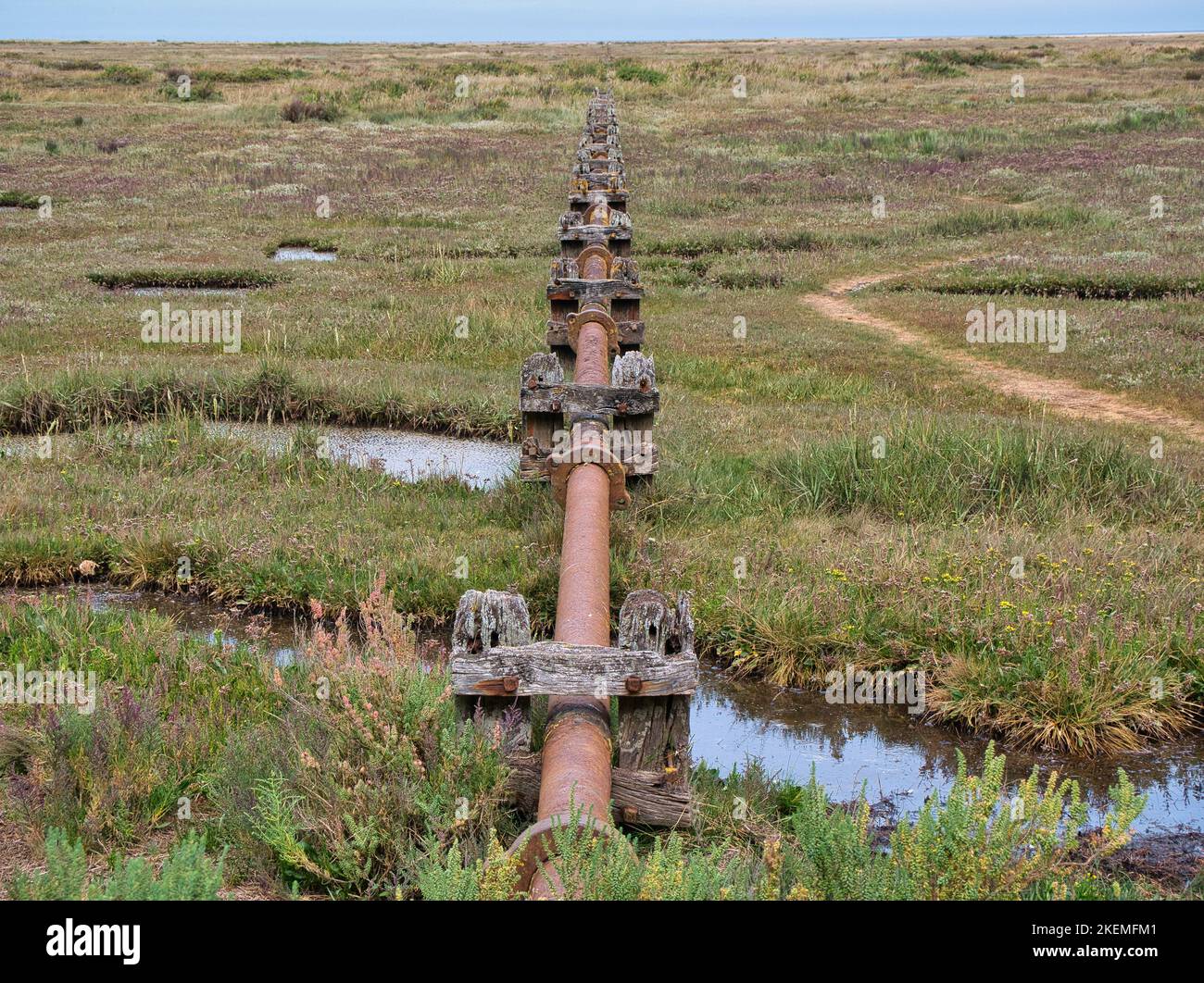 A rusting drainage pipe on weathered wooden supports at Stiffkey Salt ...