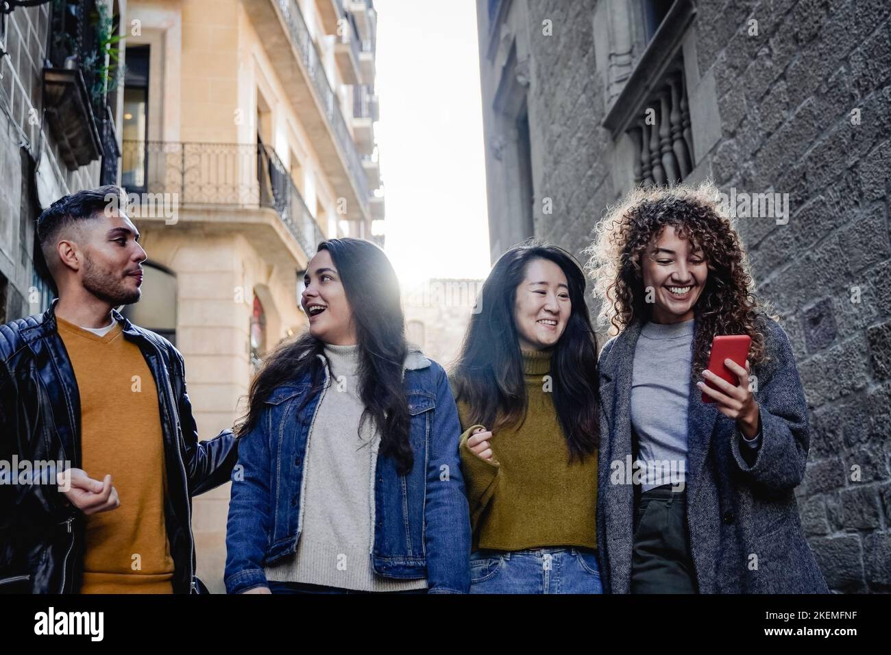 Diverse group of friends having fun walking by the city in winter time ...