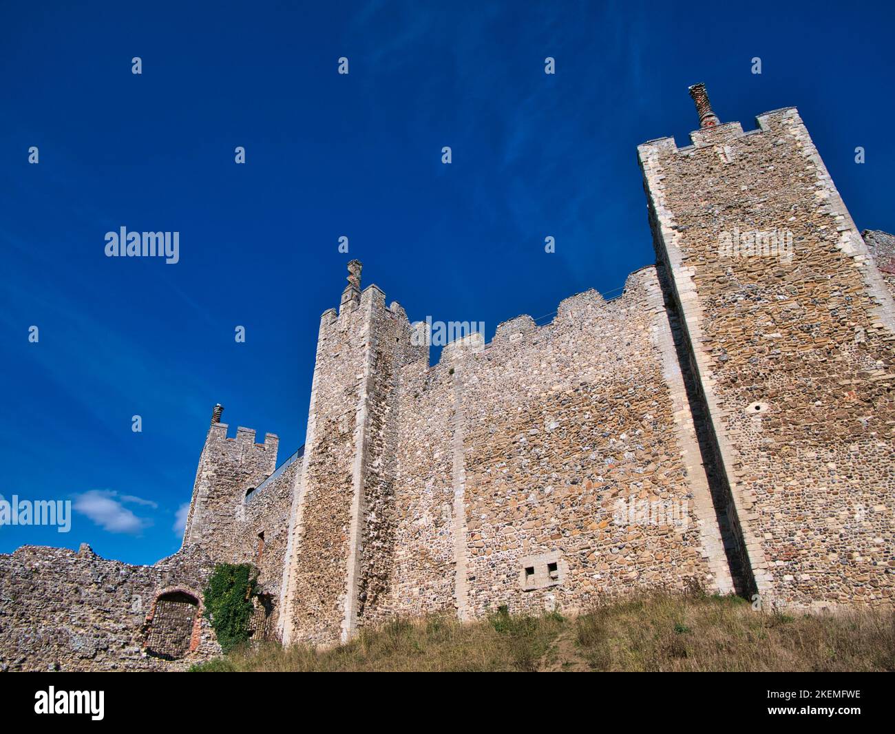 On a sunny day with a blue sky, the high walls of Framlingham Castle in ...