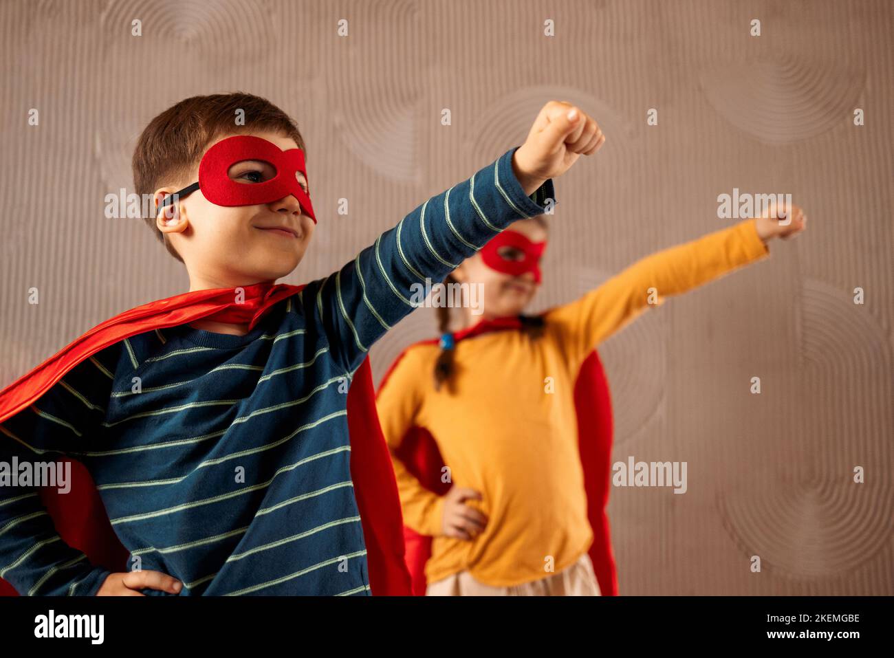 Portrait of a team of two young superheroes, brother and sister, over ...