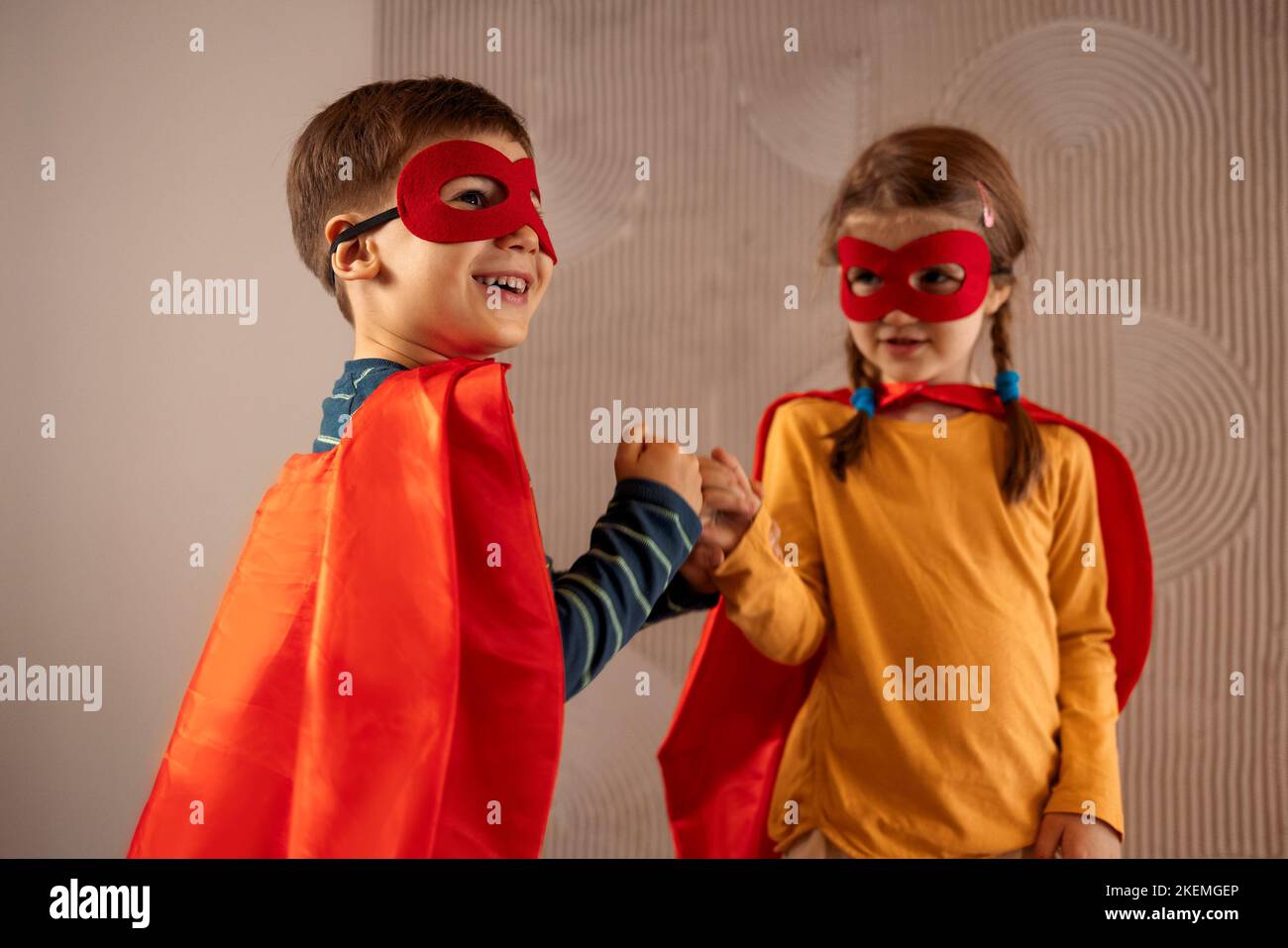Portrait of a team of two young superheroes, brother and sister, over ...