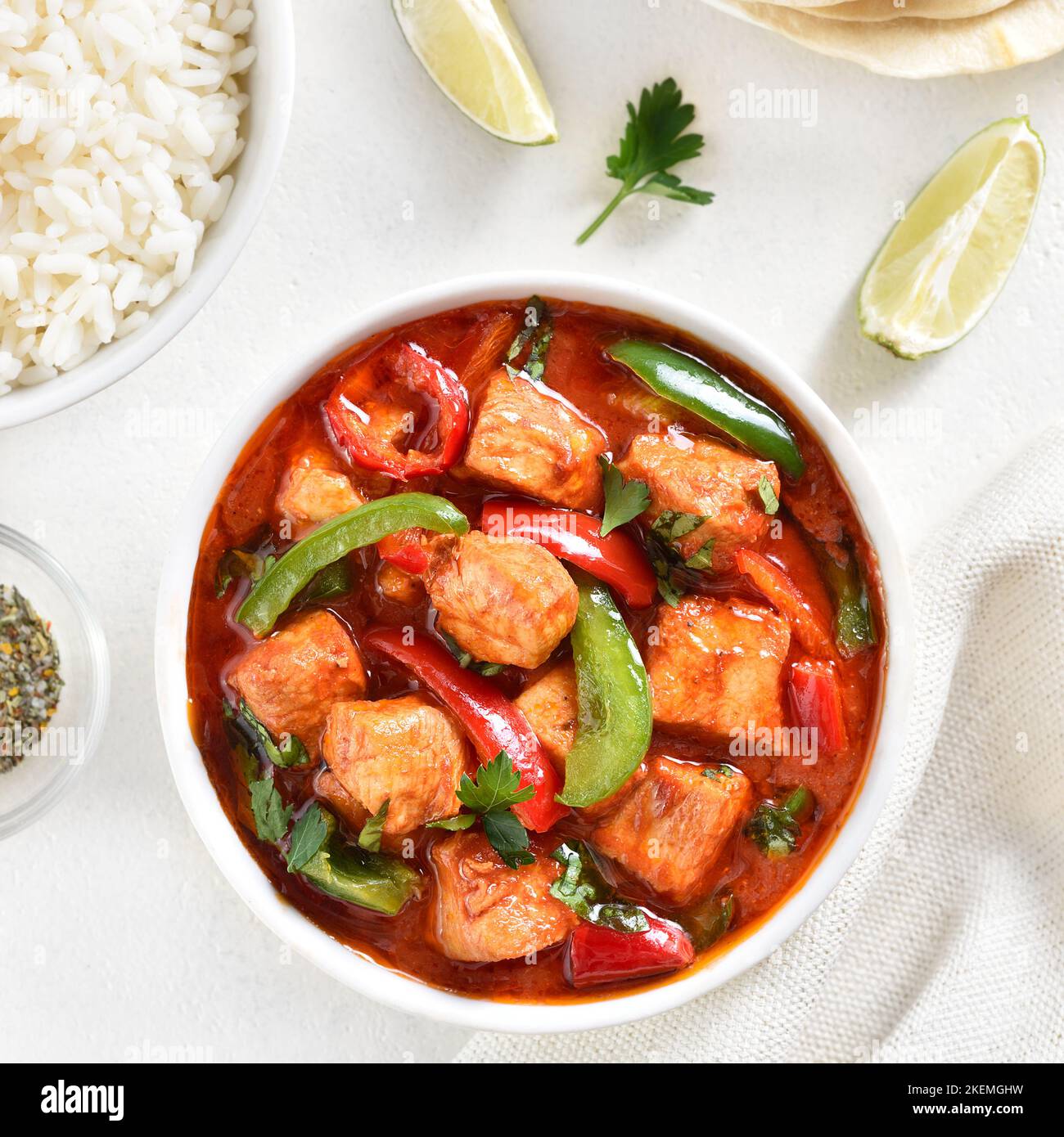 Thai style red chicken curry with vegetables in bowl over light ...