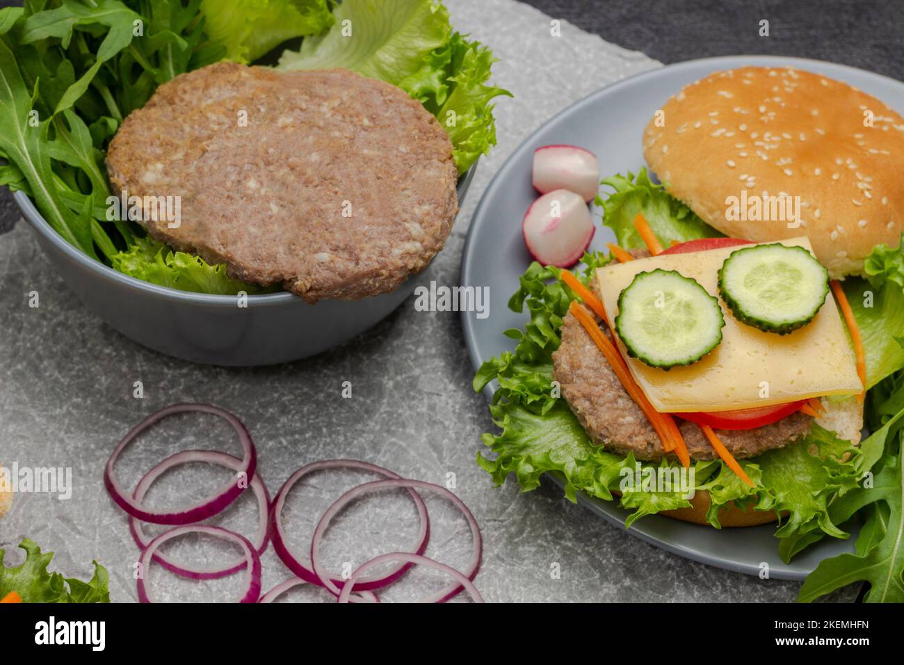 Beef burger with greens in bowl. Cheeseburger with cucumber, greens and ...