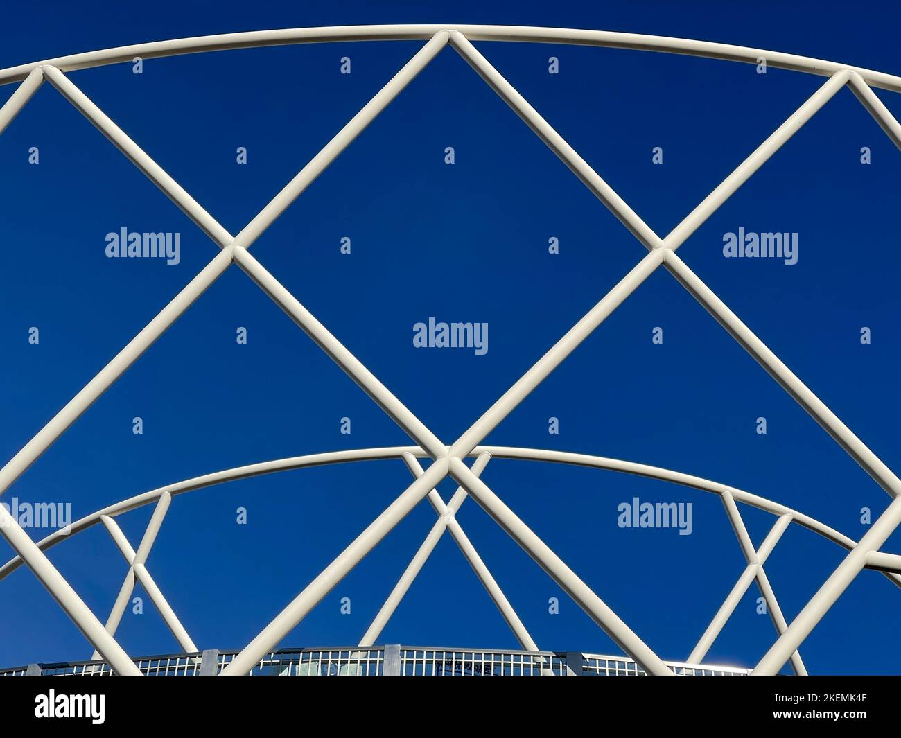 White metal pipes forming pattern structure against blue sky, modern ...