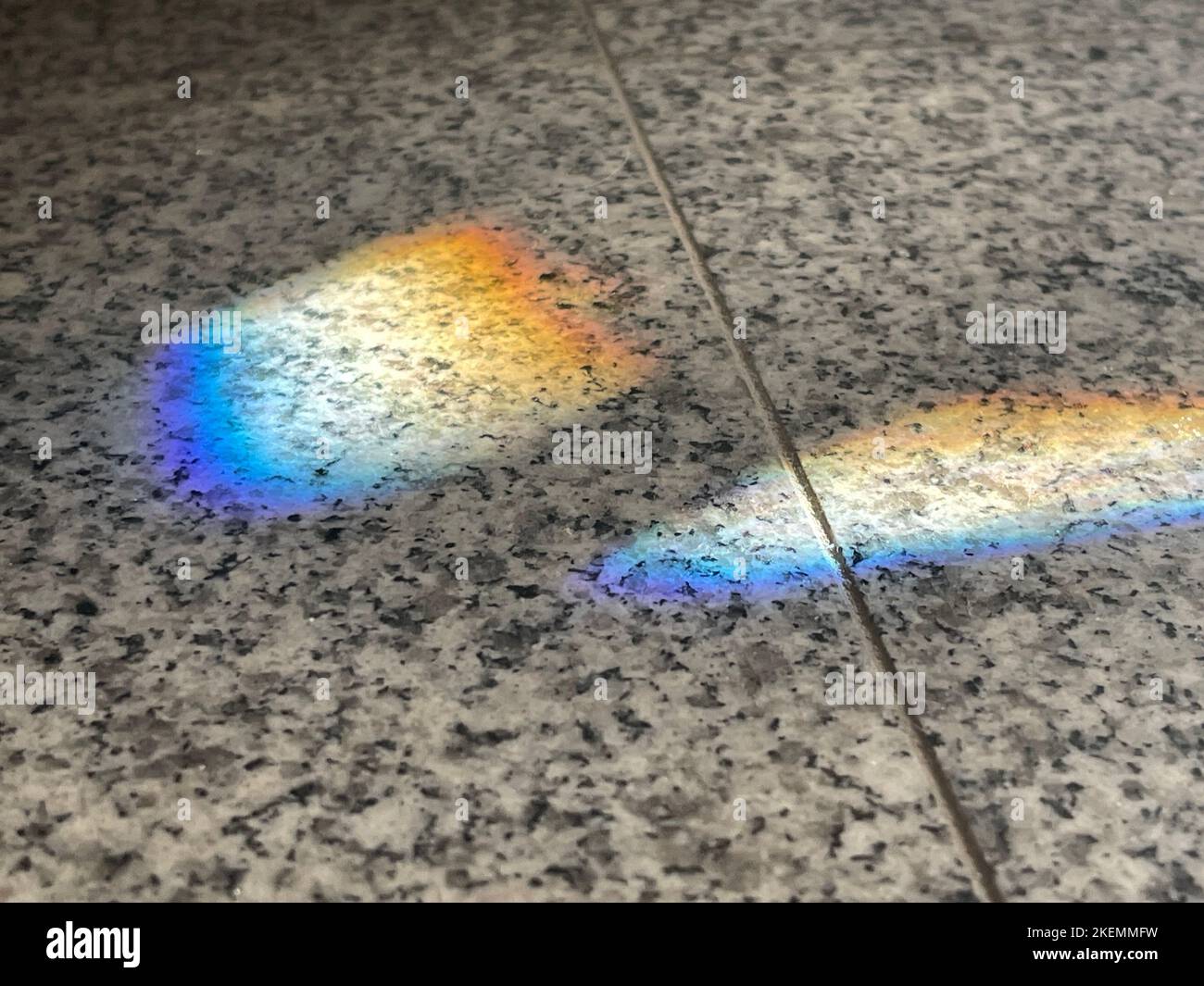 Rainbow light refraction on grey surface Stock Photo - Alamy