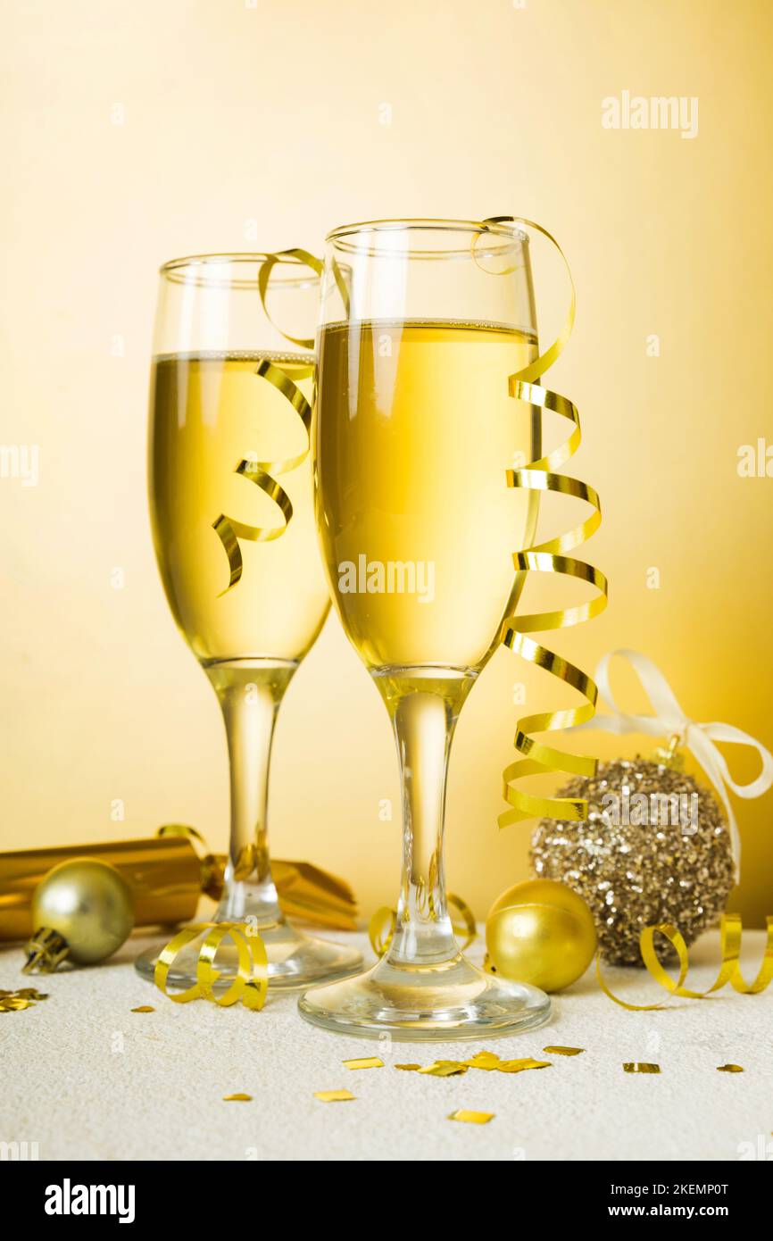 Champagne glasses and christmas decor on colored holiday background ...