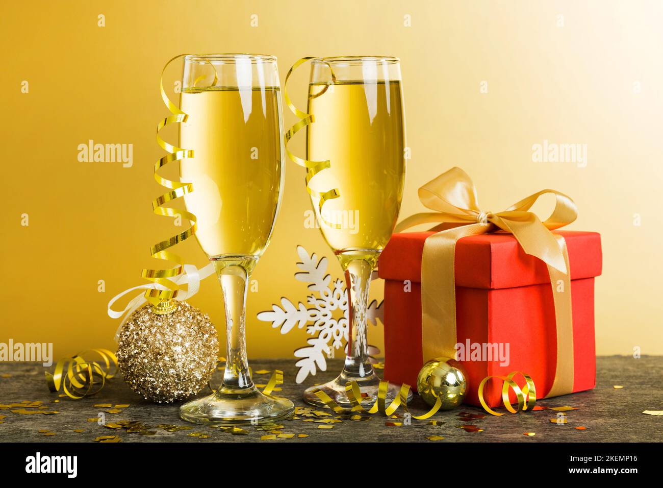 Champagne bottle with confetti, glasses and christmas decor on colored ...