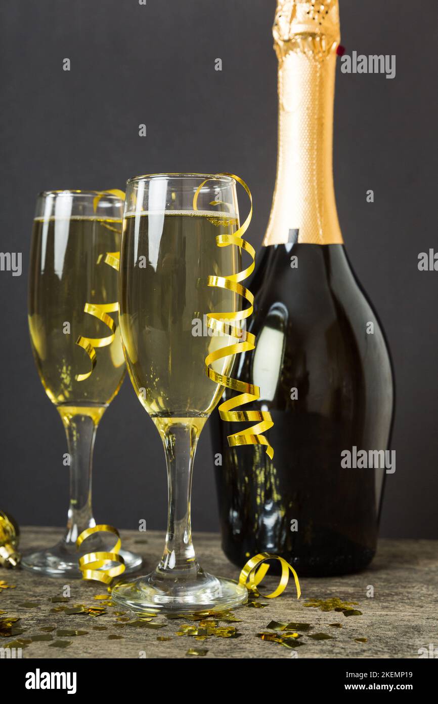 Champagne bottle with confetti, glasses and christmas decor on colored ...