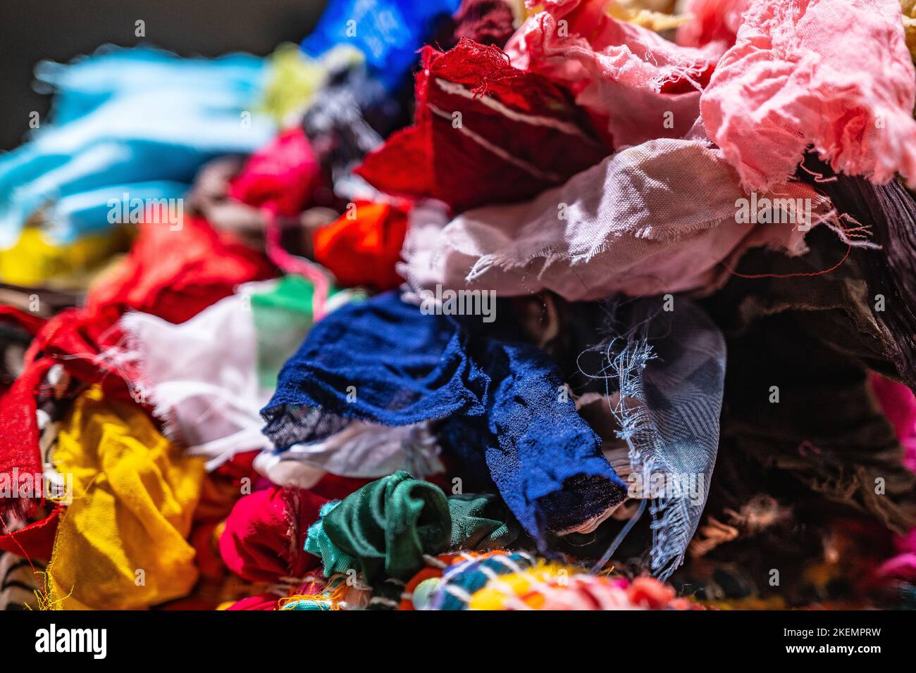 A pile of multi-colored synthetic fabrics of different structures and ...
