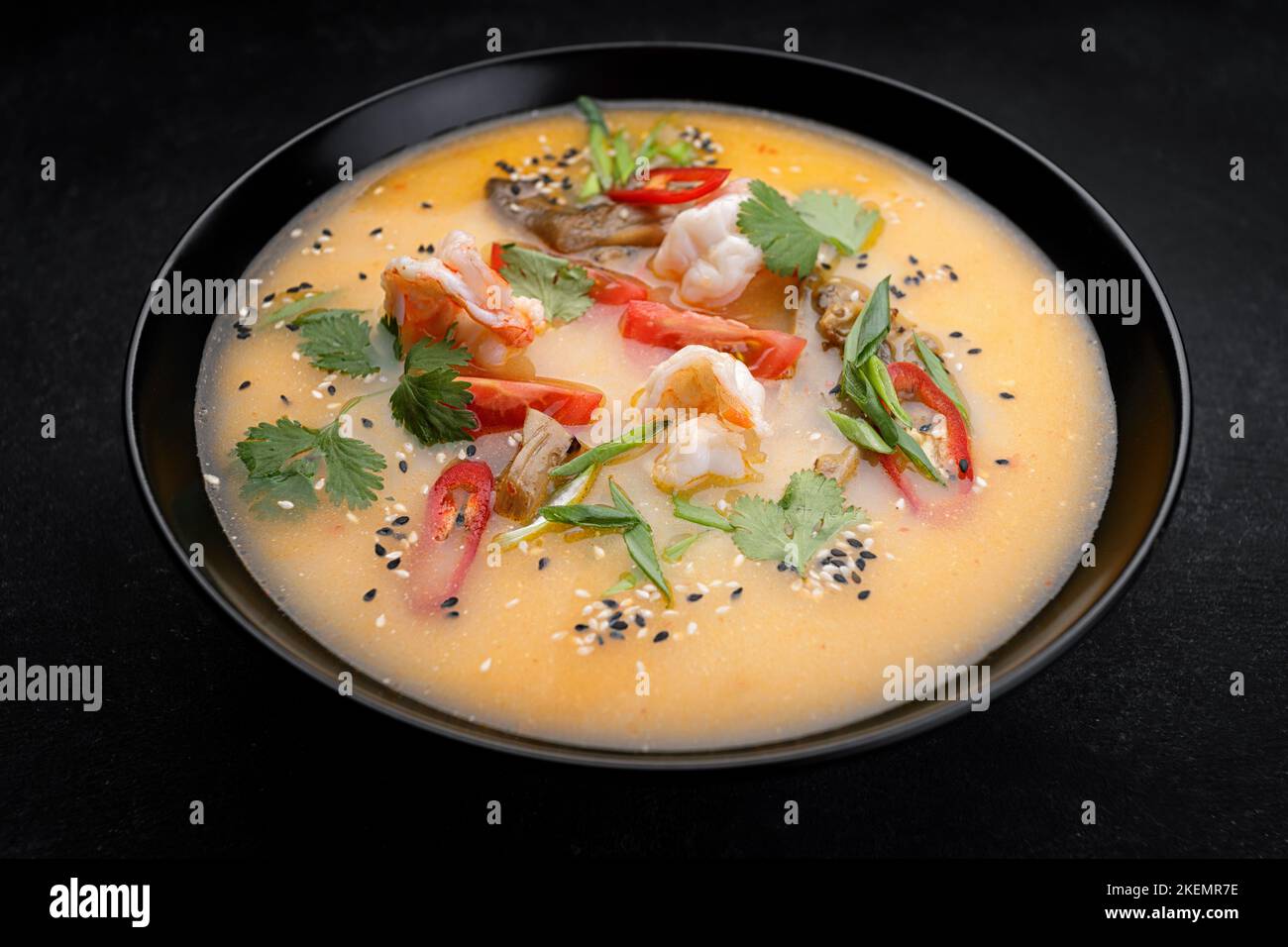 Miso soup with shrimp, mushrooms and vegetables on a dark background ...