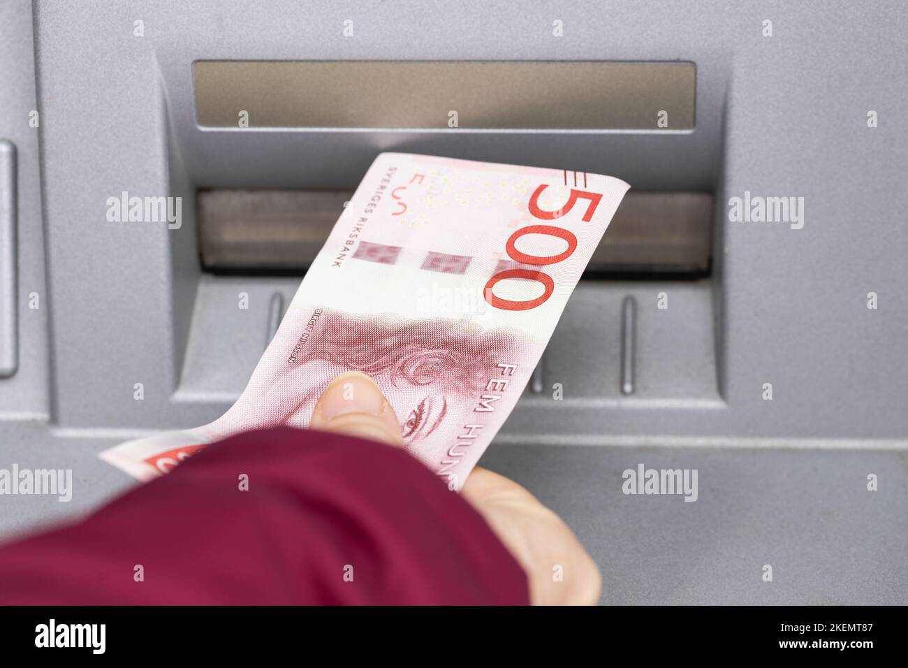 woman takes money out of an ATM, swedish 500 kronor, financial concept ...