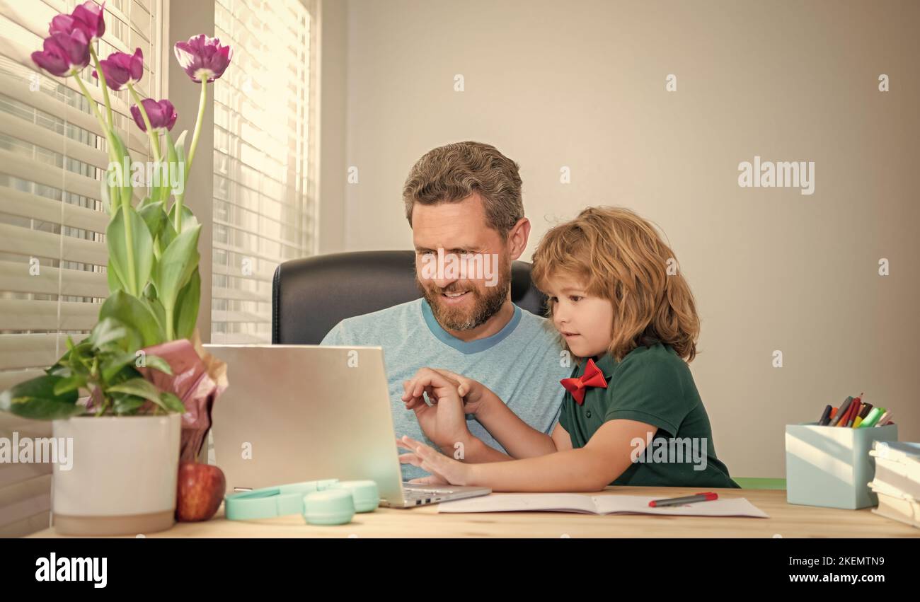 bearded dad or school private tutor teaching boy son with modern laptop ...