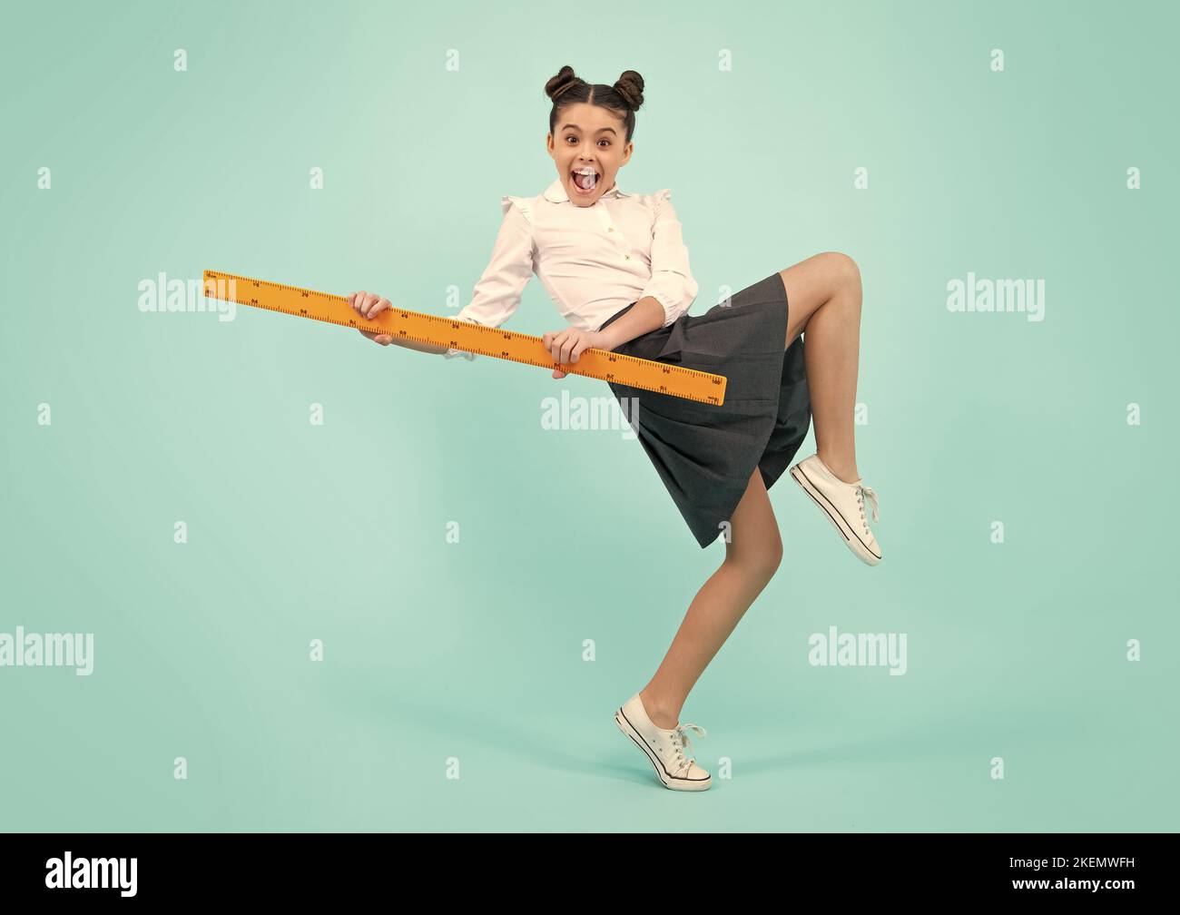 School girl holding measure for geometry lesson, isolated on blue ...