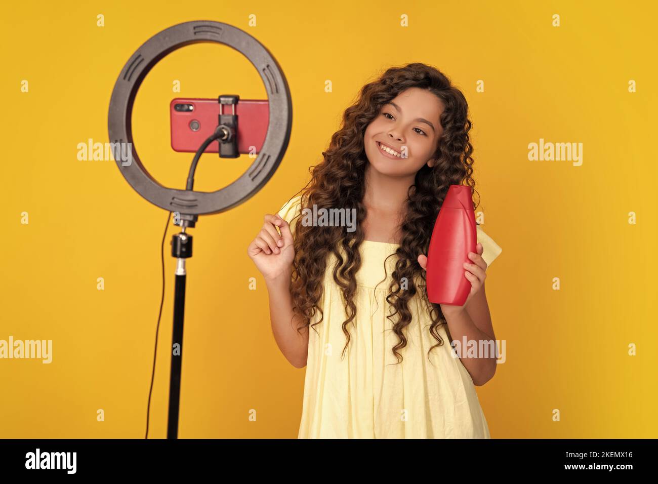 Teen girl blogger influencer hold hair conditioner or shampoo bottle ...