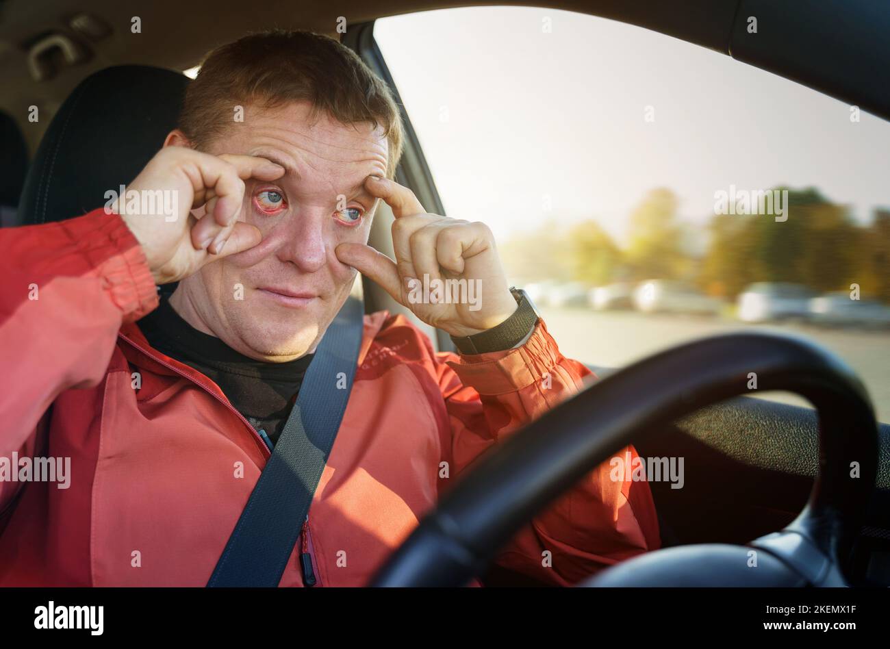 A tired driver holds his eyelids with his fingers, preventing them from ...