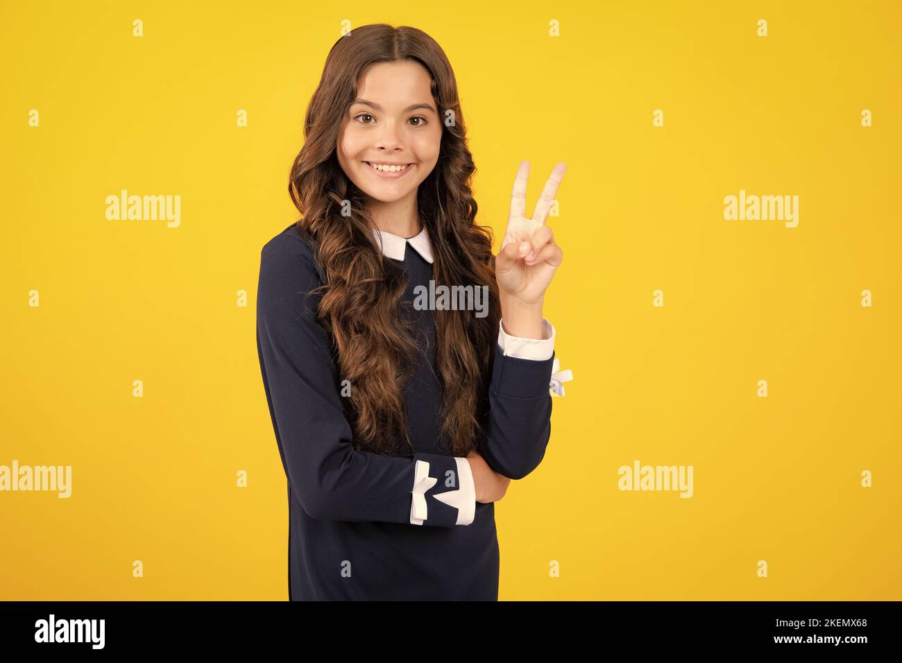 Teenager child girl standing over isolated yellow background showing ...