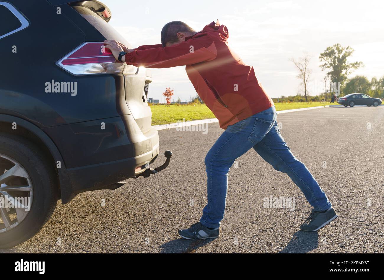 A man pushes his broken car to a parking lot. Transport concept Stock ...