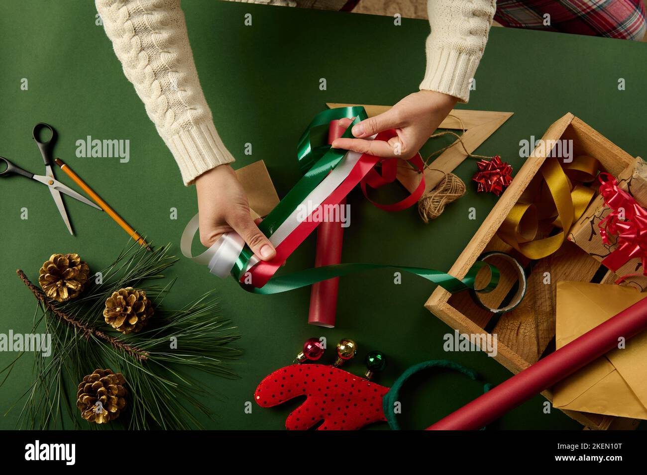 Top view woman's hands holding red, white and green shiny decorative ...