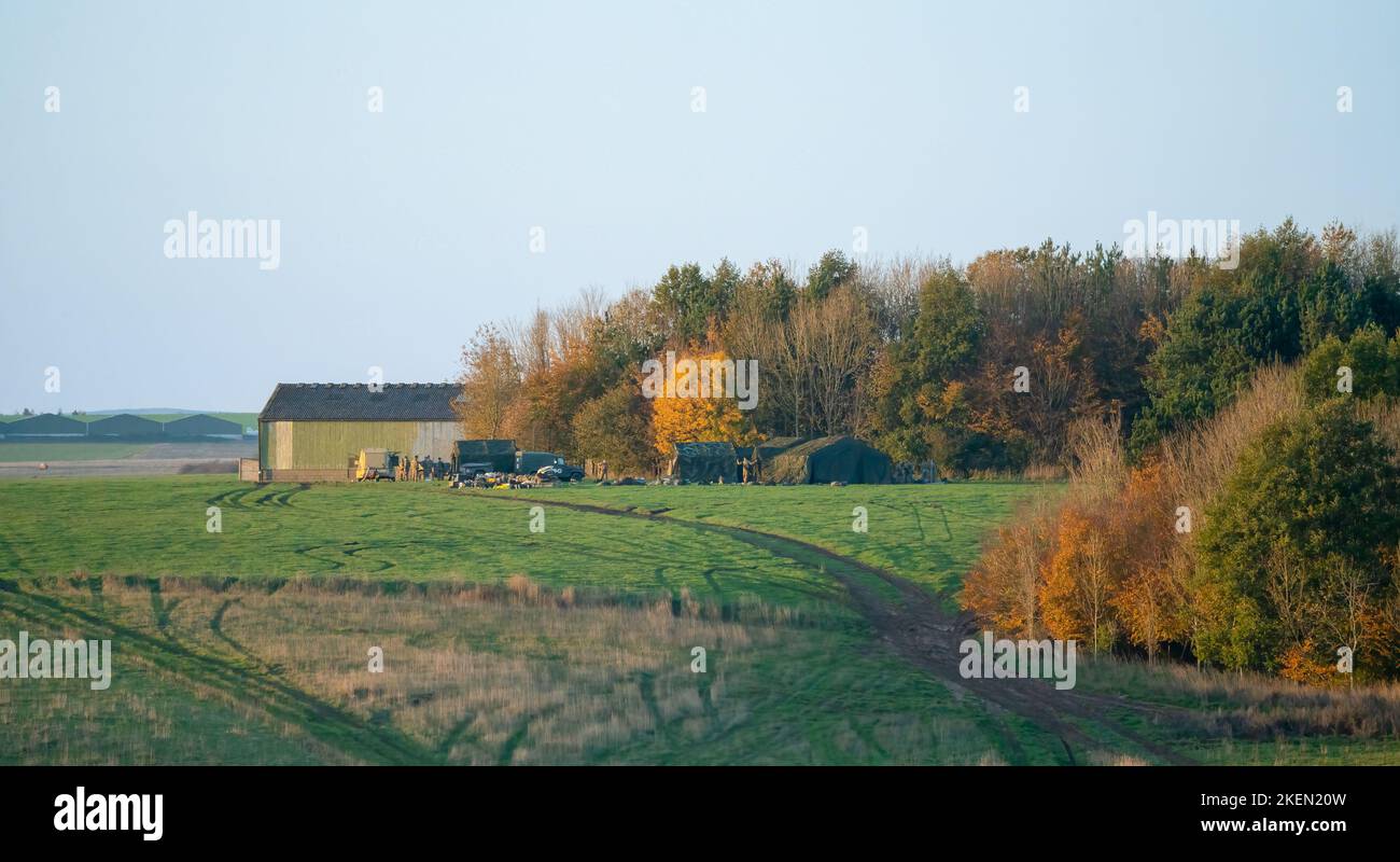 British army soldiers camped on the edge of woodland preparing for a ...