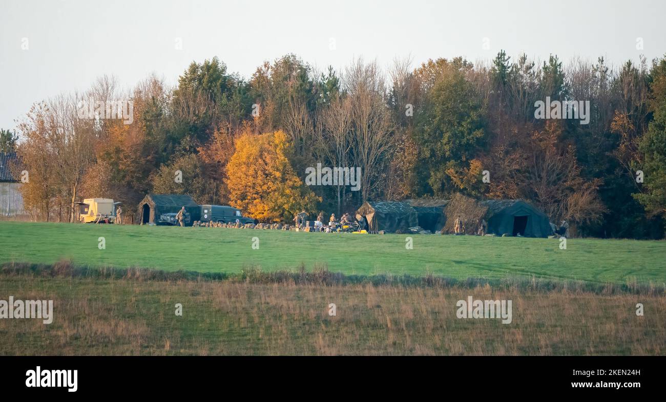 British army soldiers camped on the edge of woodland preparing for a ...