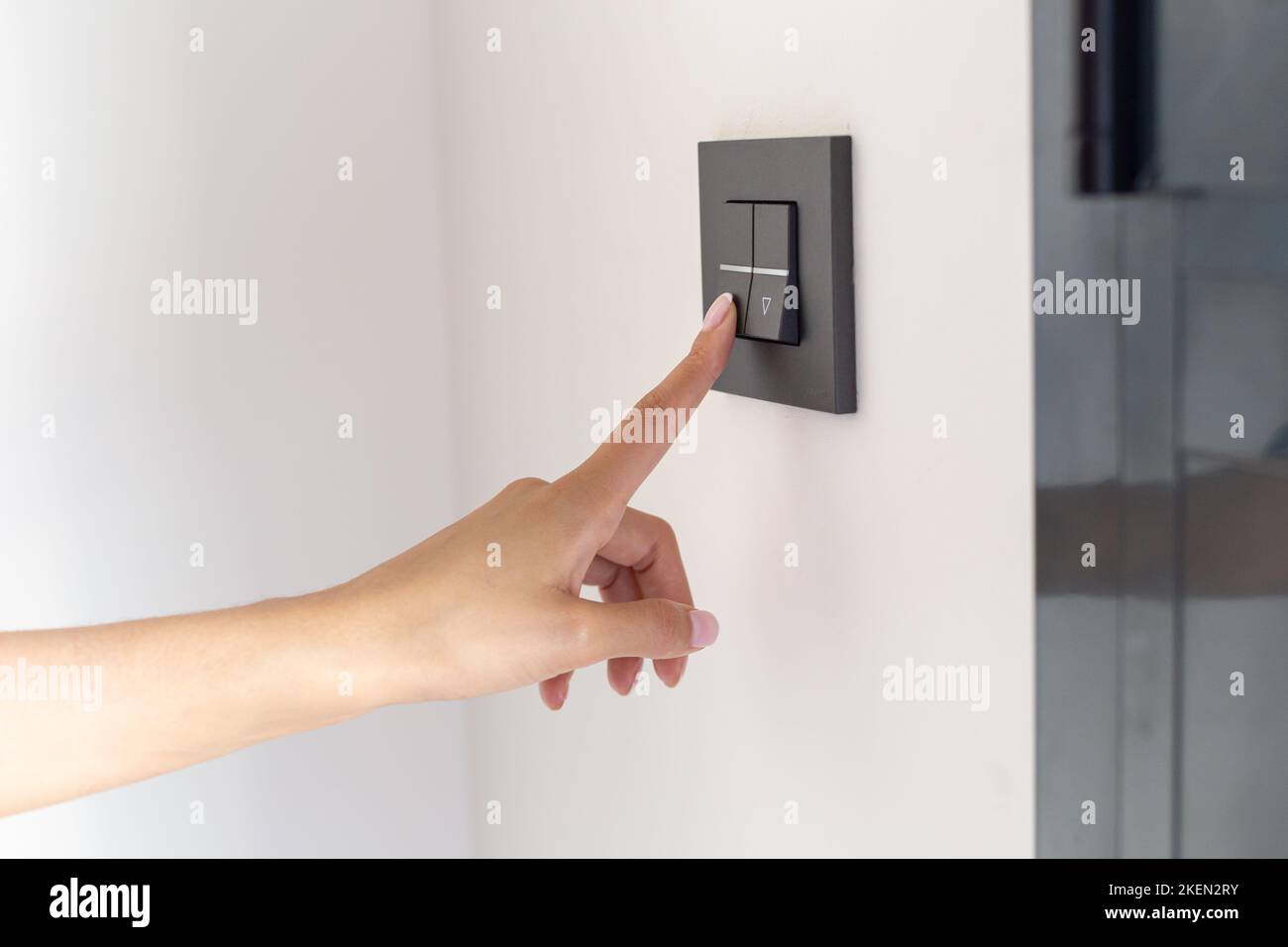Close up of young woman's hand raising the blinds in her room with a ...
