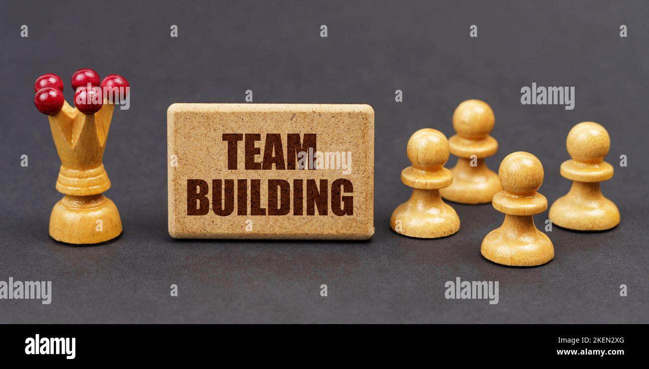 Business concept. On a black background, chess and a sign with the ...