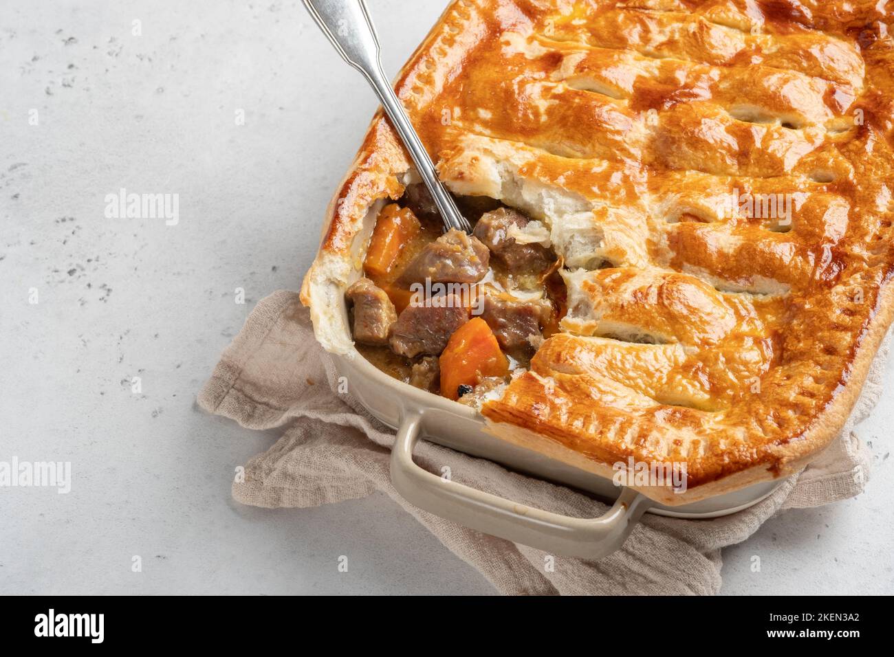 English beef steak pie with crispy puff pastry close-up in a baking ...