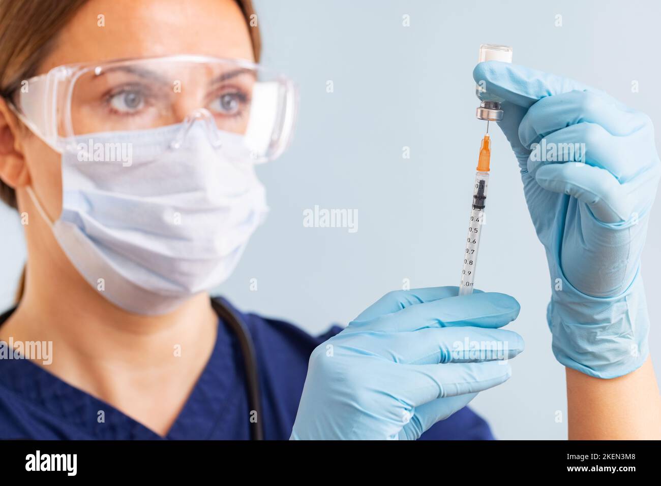 Doctor in surgical mask and gloves preparing syringe for injection ...