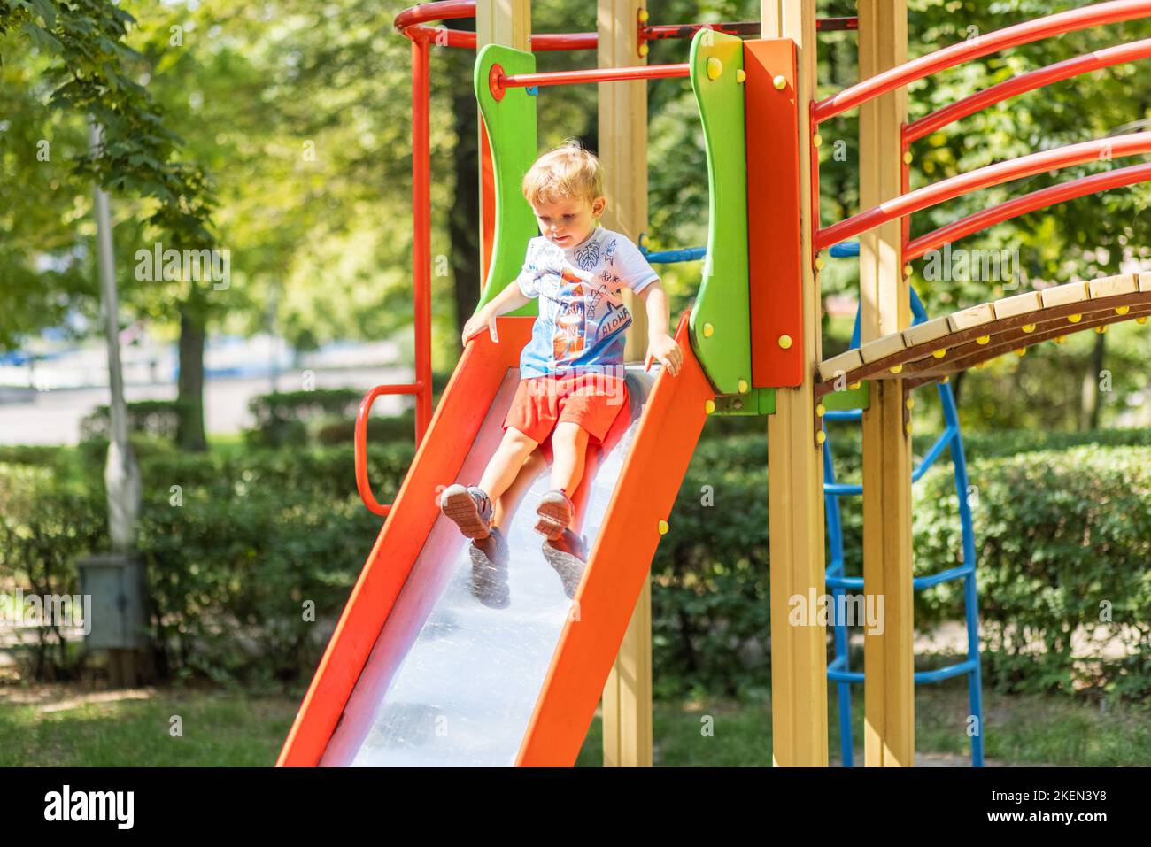 Active kid on colorful slide. Child playing on outdoor playground Stock ...