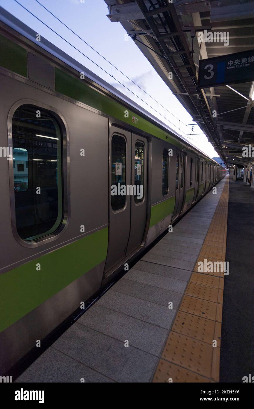A local train stops at dusk at Shimosuwa Station on the Chuo Main Line ...
