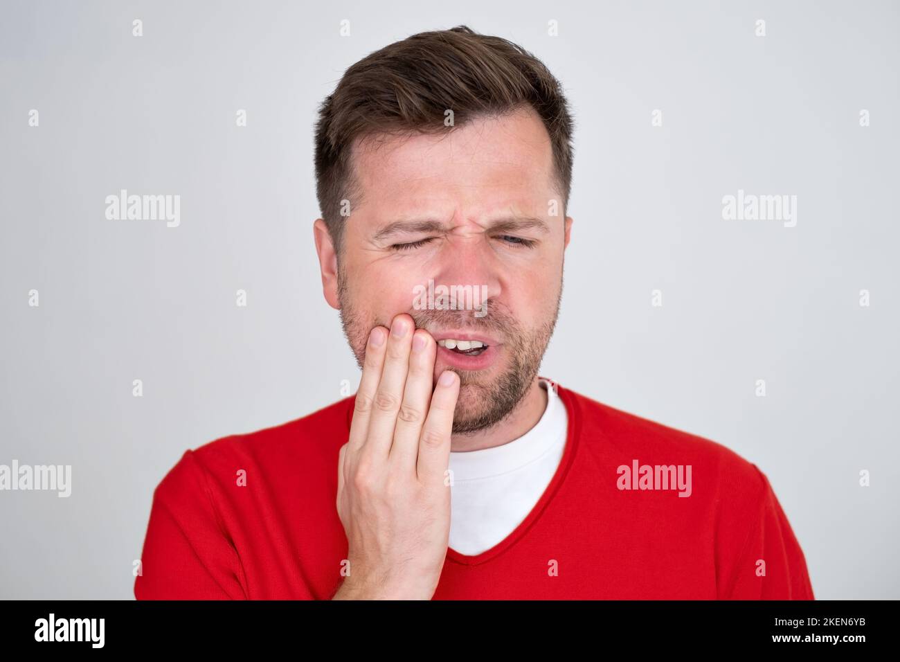 Sad young man having a toothache isolated over white background Stock ...