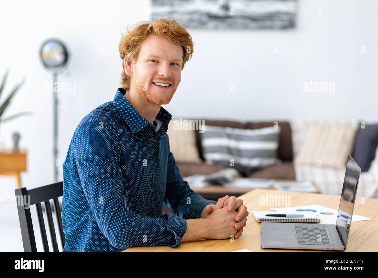 Portrait of smiling confident man executive sitting at the workplace in ...