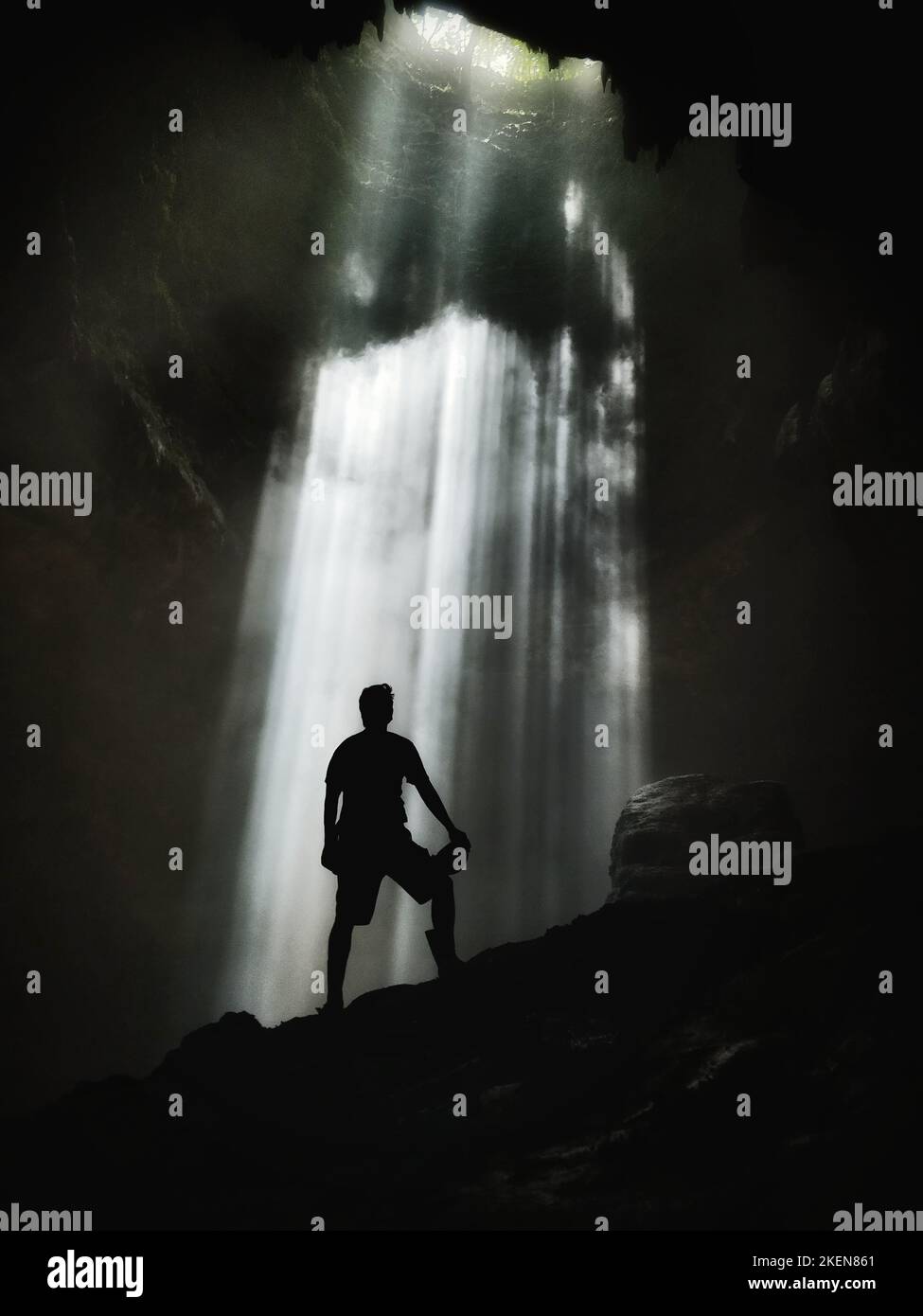 A vertical shot of a silhouette of a man inside a cave Stock Photo - Alamy