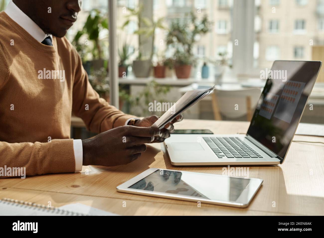 Young African American businessman examining business documents while ...