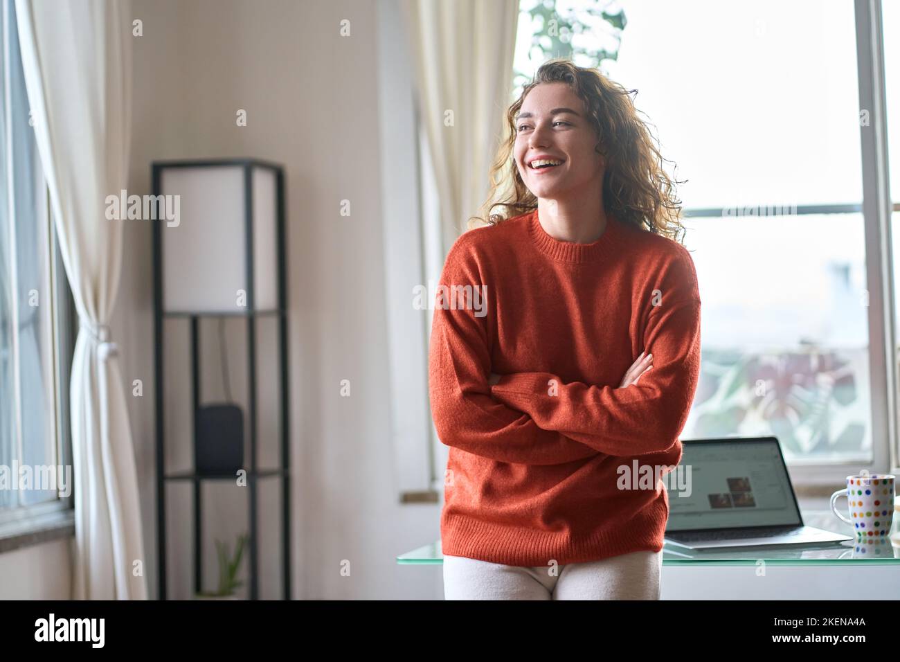 Happy smiling young woman laughing standing in cozy apartment interior ...